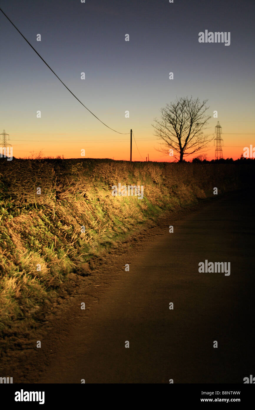 empty lonely country lane track lit by car headlights at night Stock ...