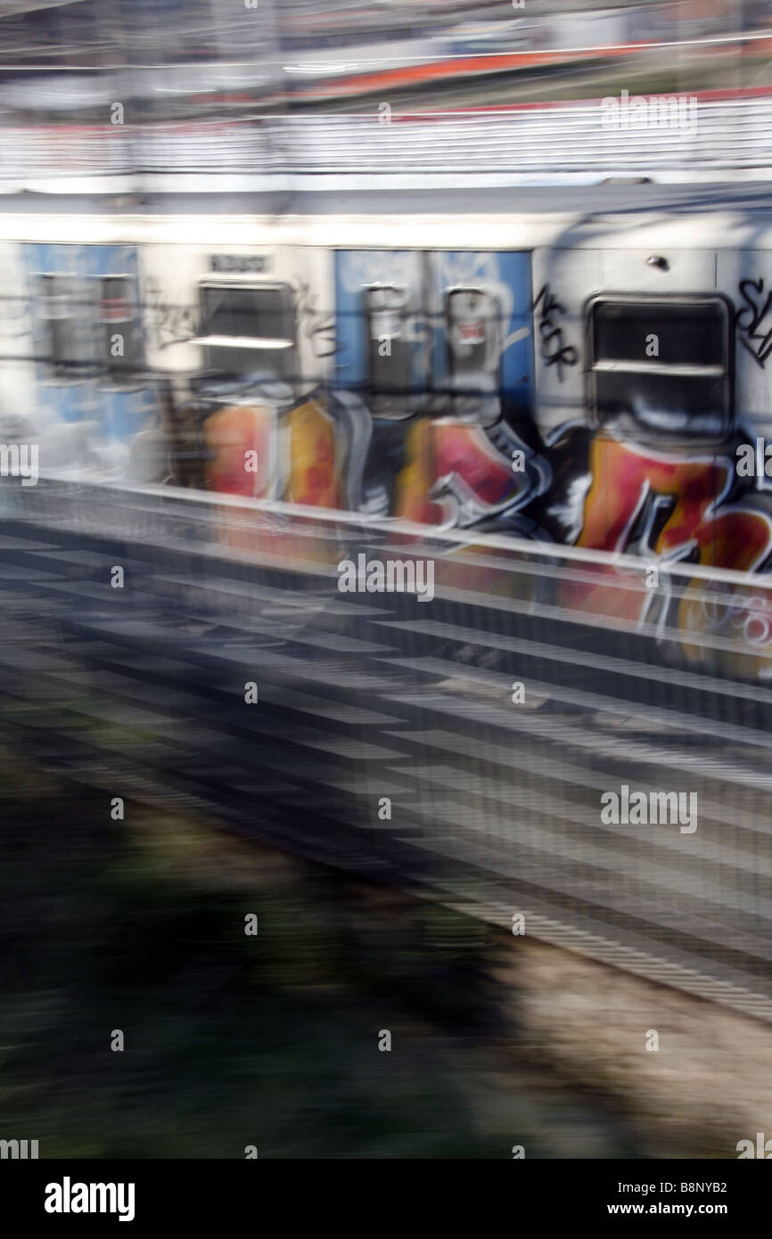 fast metro train covered with graffiti art on tracks in city Stock ...