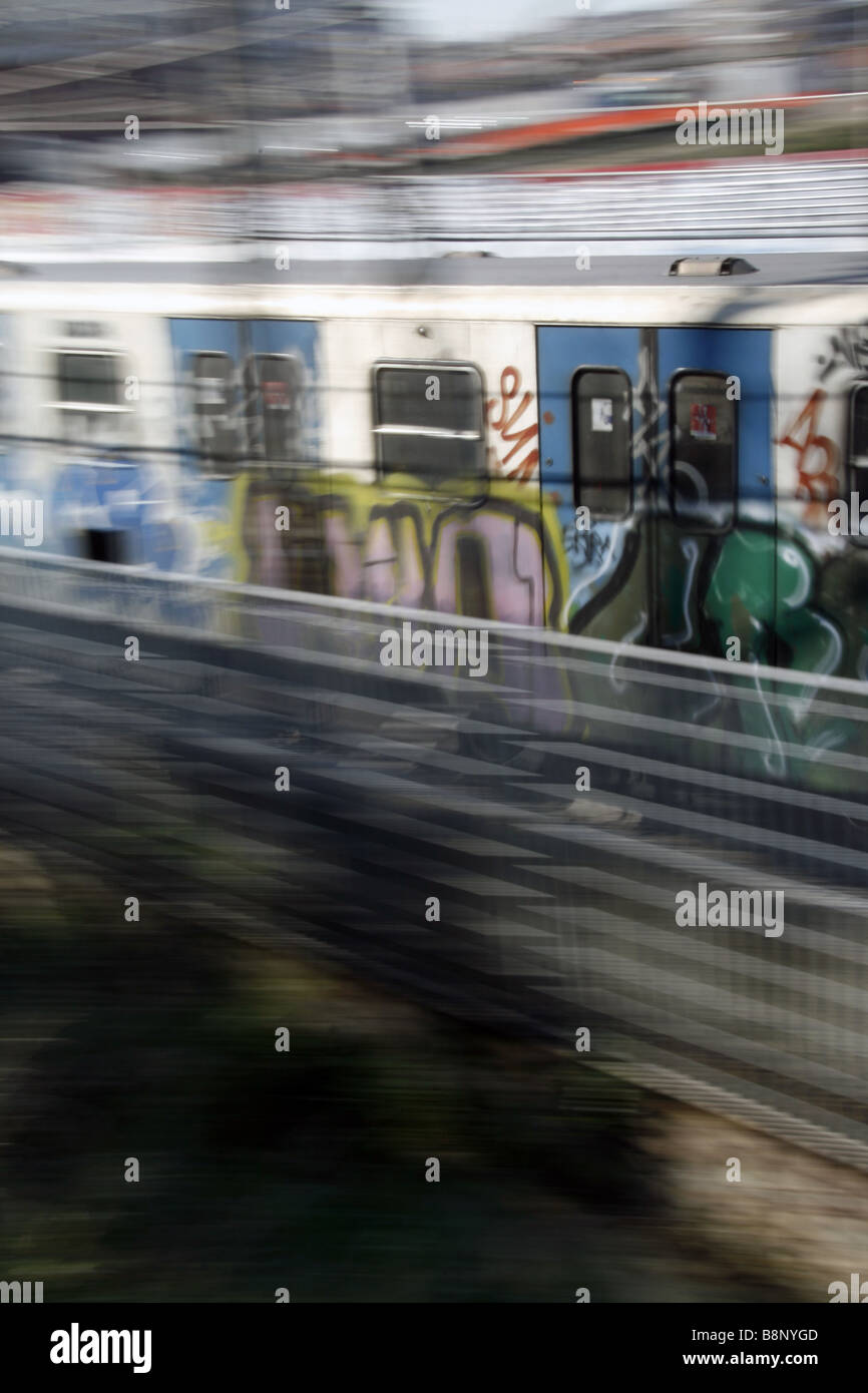 fast metro train covered with graffiti art on tracks in city Stock ...