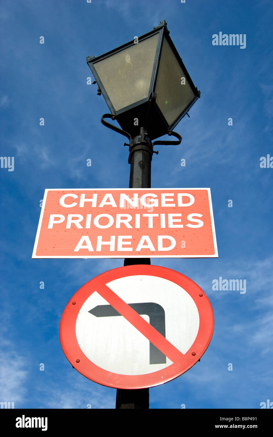 british road signs fixed to a lampost stating changed priorities ahead ...