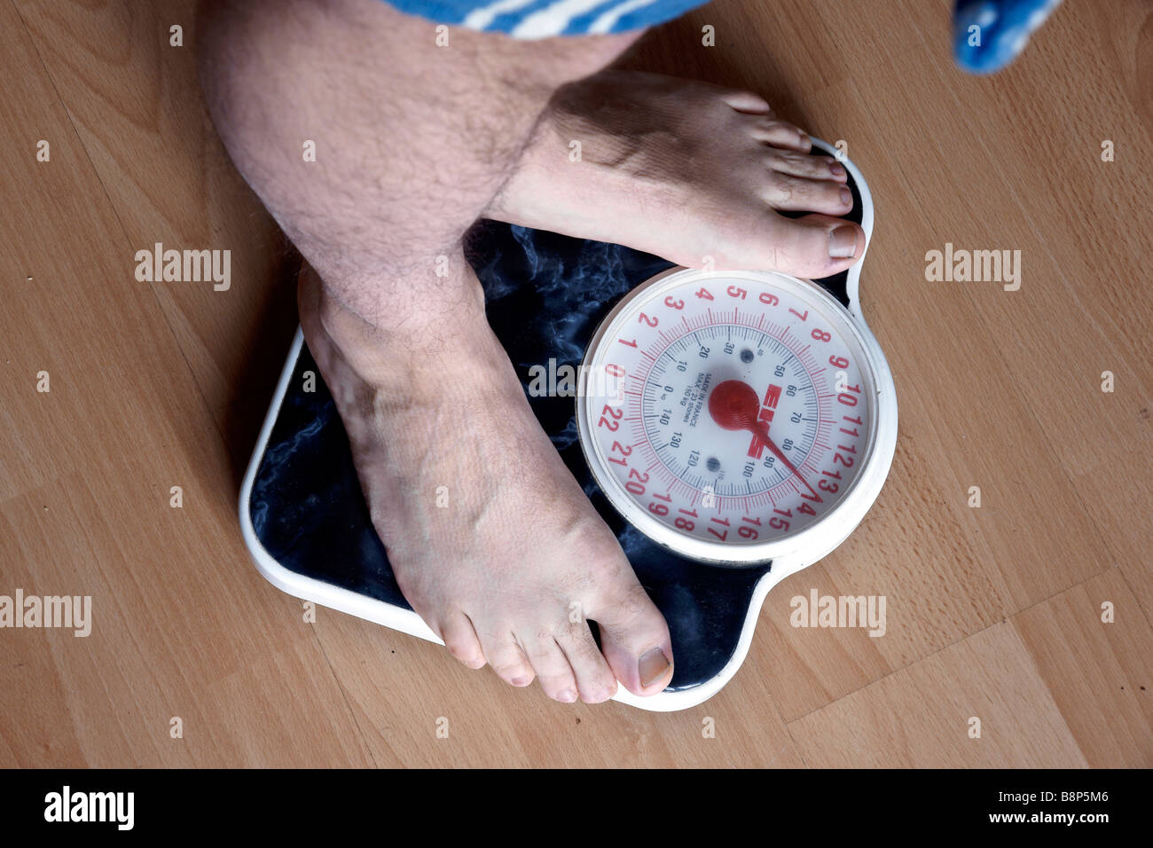 Man weighing himself on scales hi-res stock photography and images - Alamy