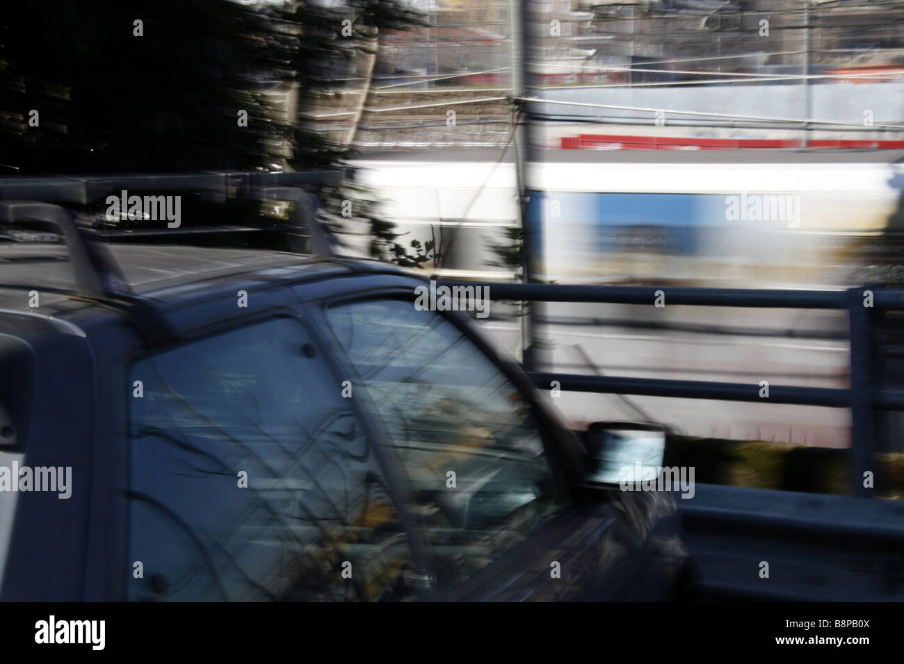 fast metro train covered with graffiti on tracks and station car park ...