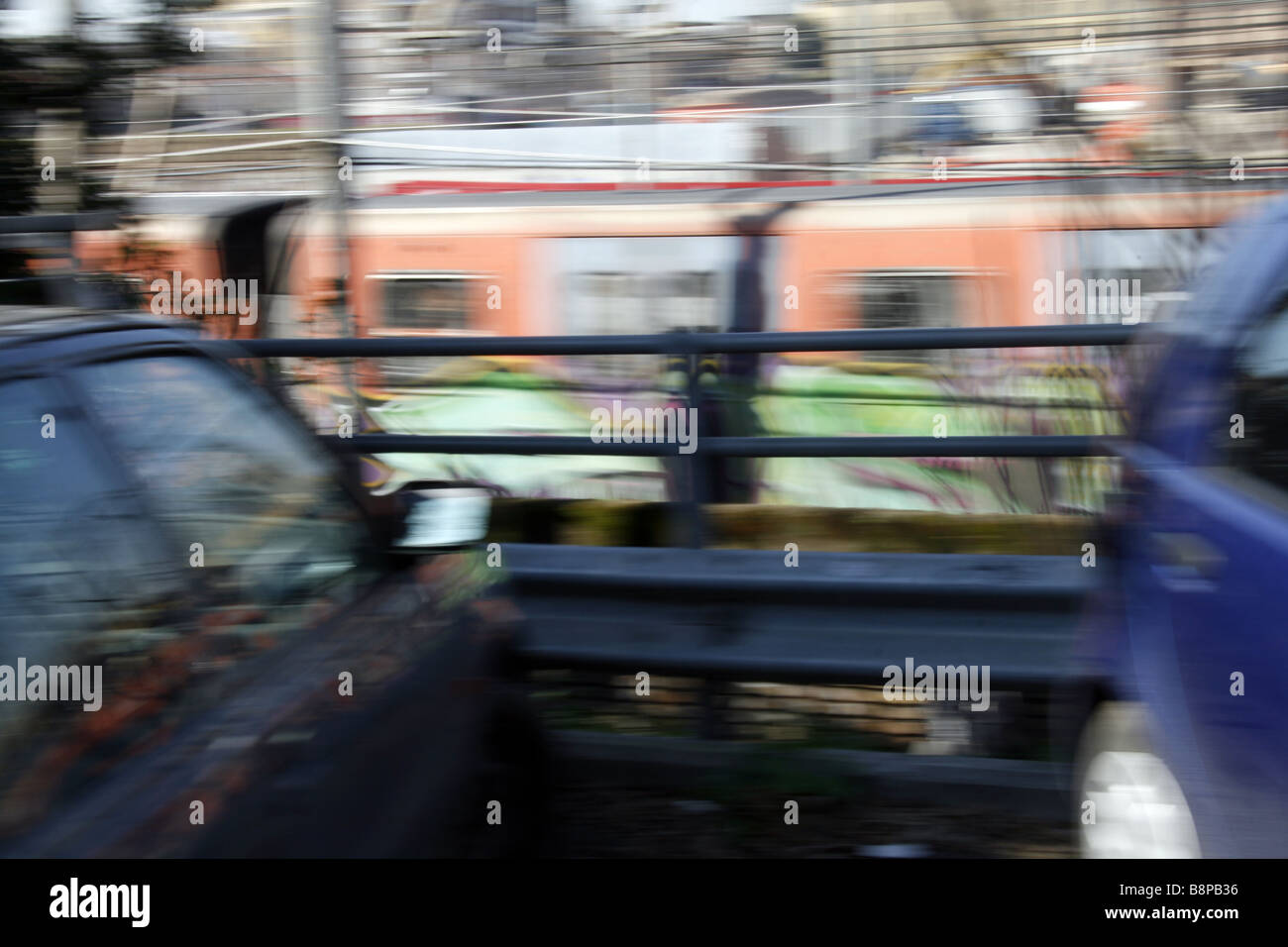 fast metro train covered with graffiti on tracks and station car park ...