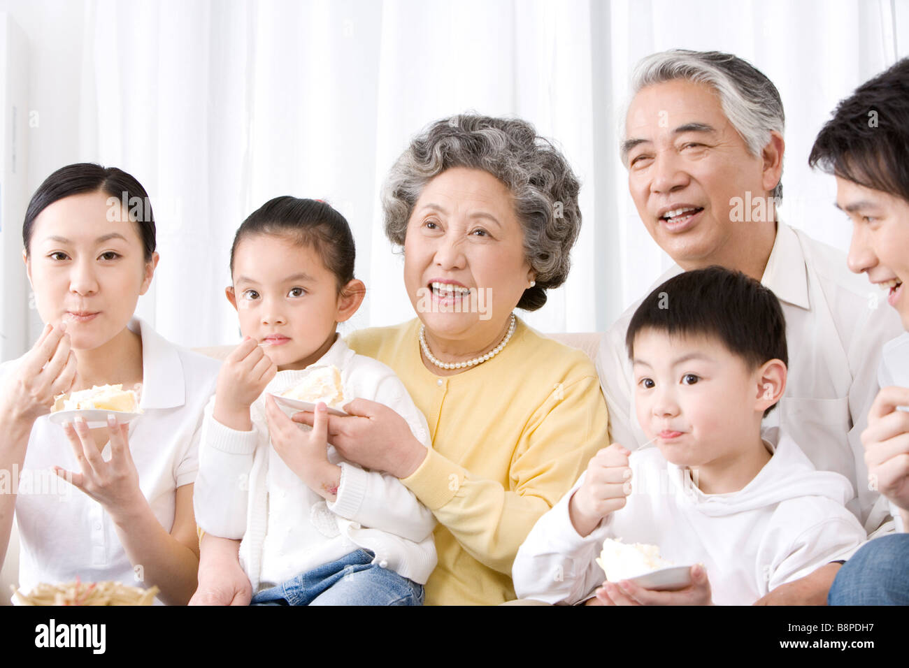 Three generation family eating cake smiling portrait Stock Photo - Alamy