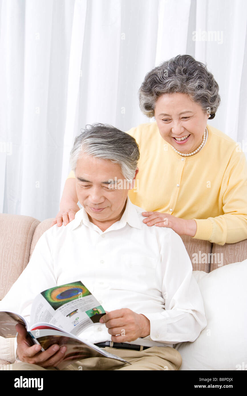 Grandparents looking at magazine Stock Photo - Alamy