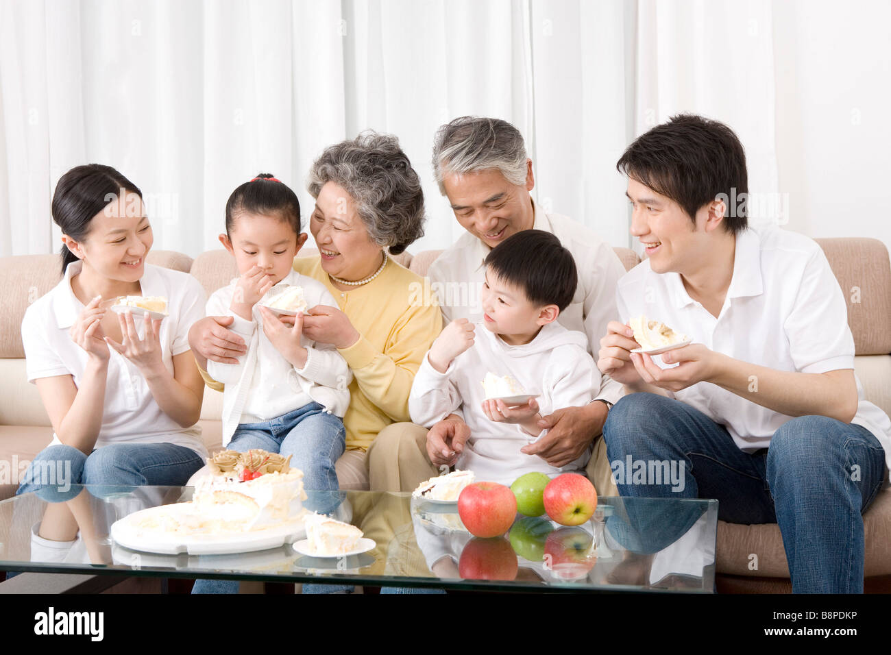 Three generation family eating birthday cake smiling portrait Stock ...