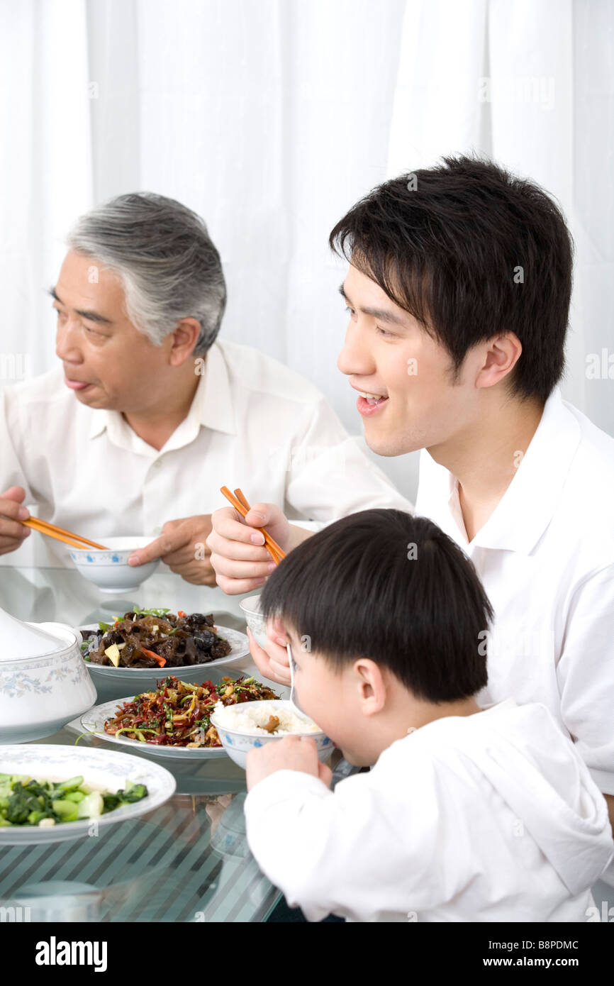 Three generation family eating meal Stock Photo - Alamy