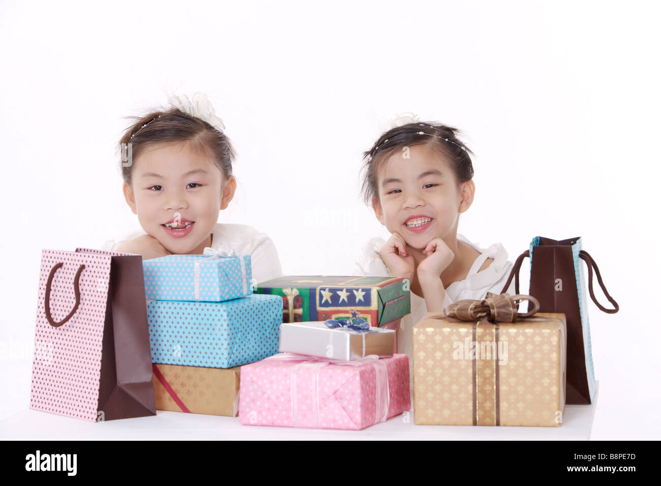 Two girls with stack of gifts Stock Photo - Alamy