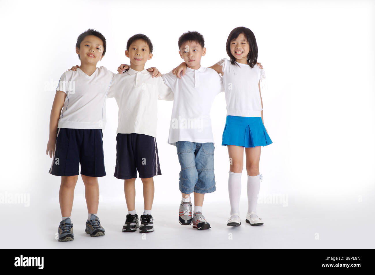 Four children standing side by side Stock Photo - Alamy