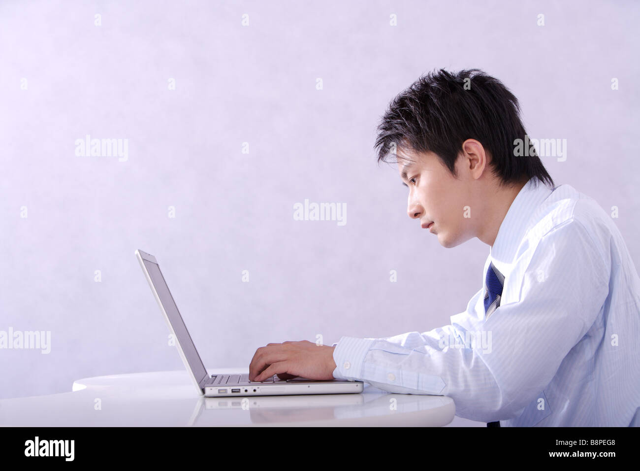 Young businessman using laptop side view Stock Photo - Alamy