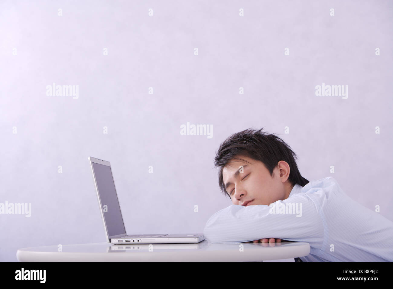 Young businessman napping by laptop side view Stock Photo - Alamy