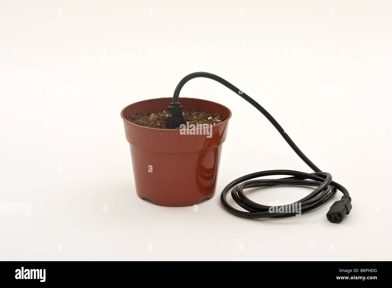Electric computer power plug wired into a flower pot filled with ...