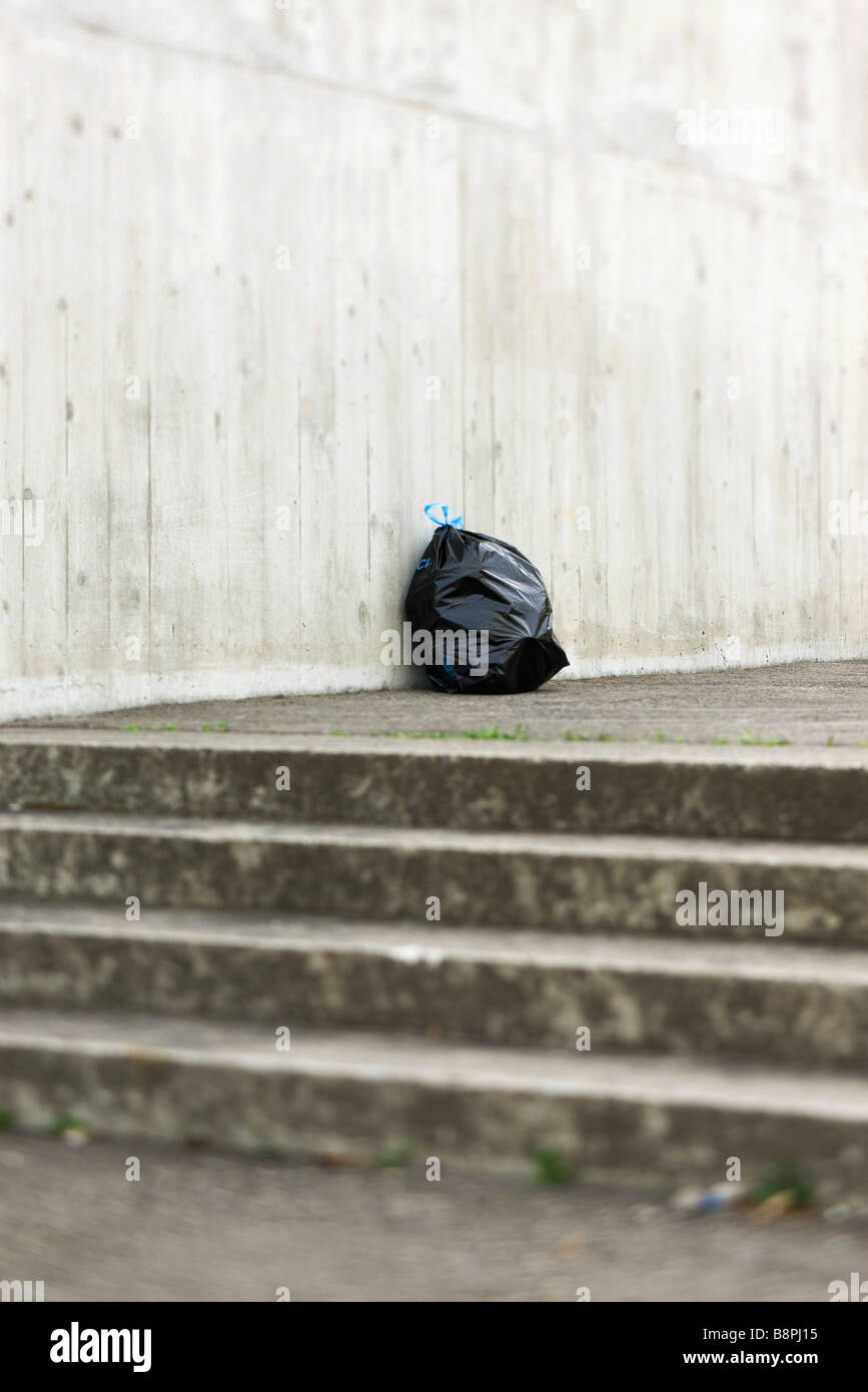 Bag of garbage sitting at top of steps Stock Photo - Alamy