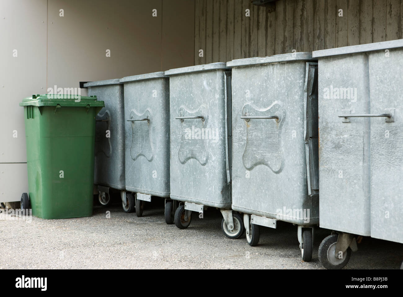 Garbage cans lined up along wall Stock Photo - Alamy