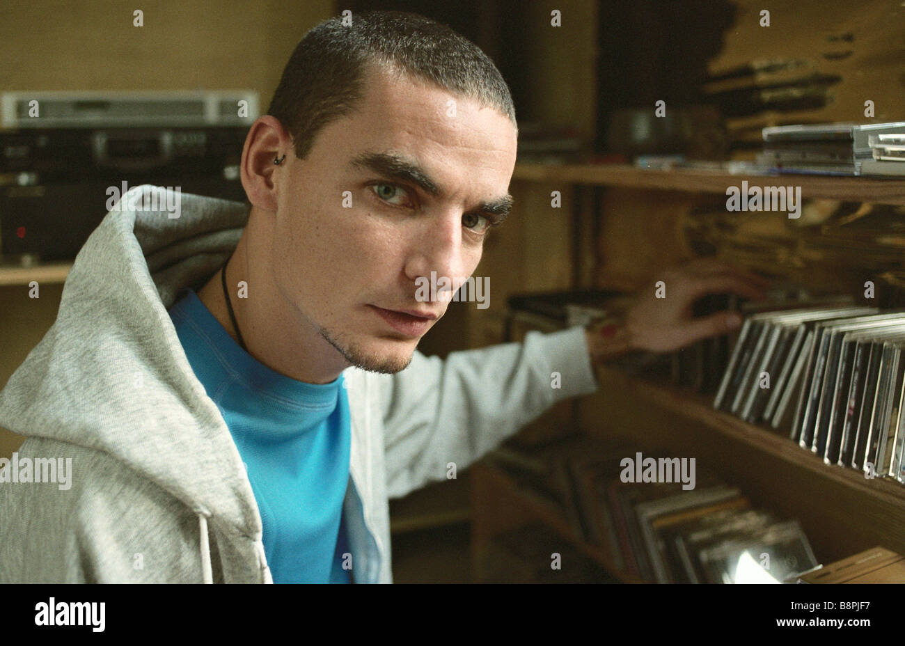 Young man selecting CD from collection on shelf Stock Photo - Alamy