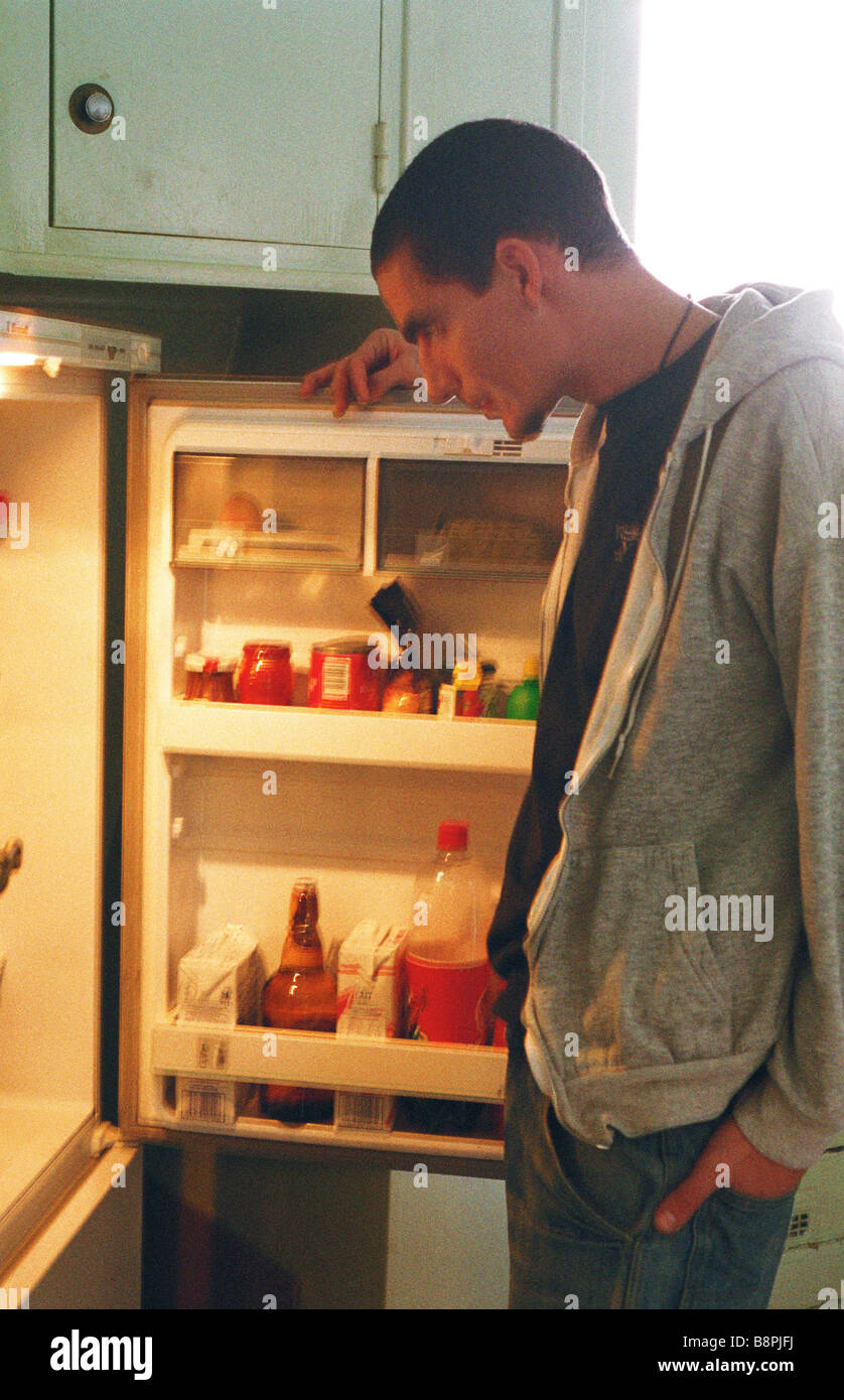 Young man standing in front of open refrigerator Stock Photo - Alamy