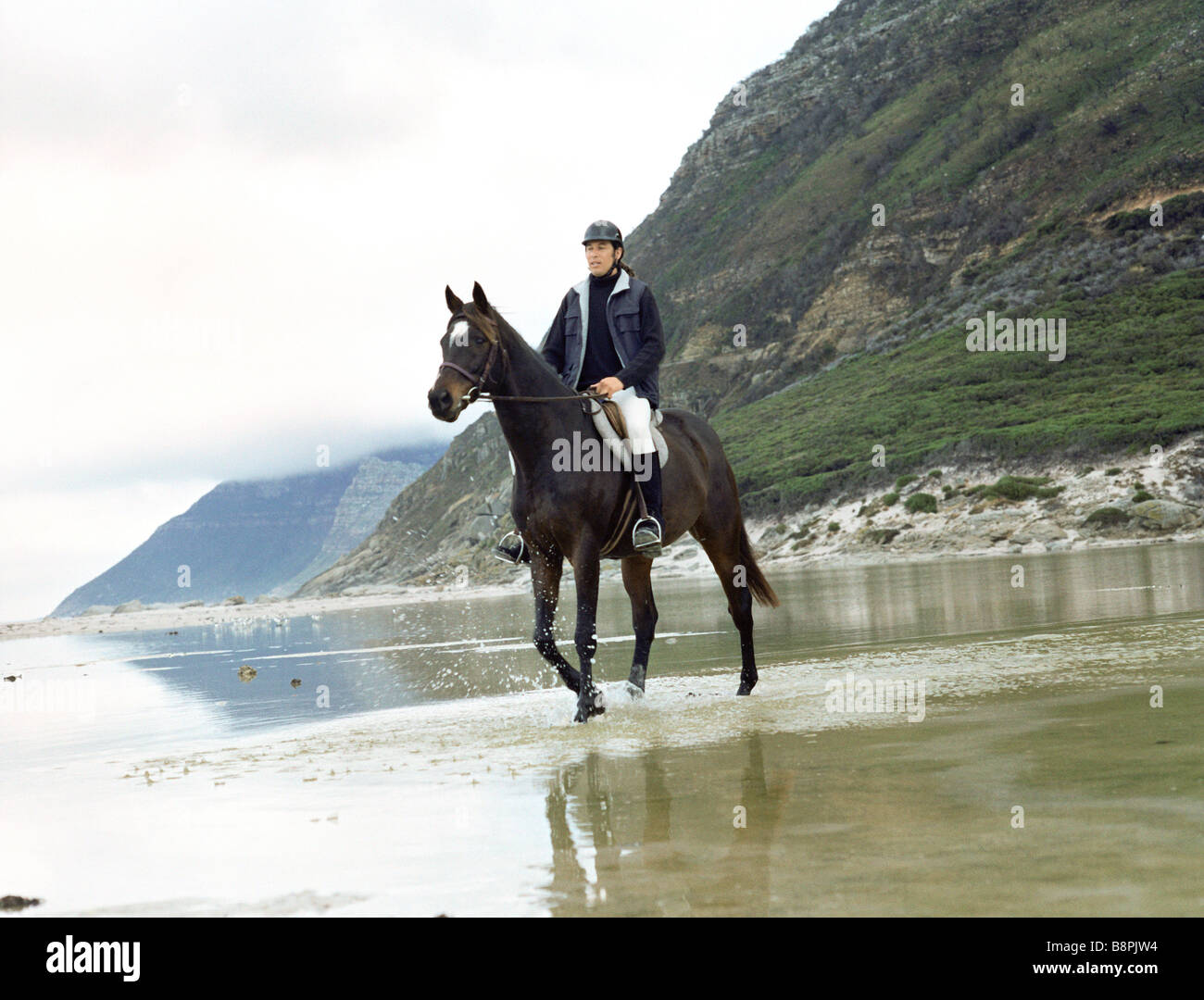 Man riding horse through water Stock Photo - Alamy