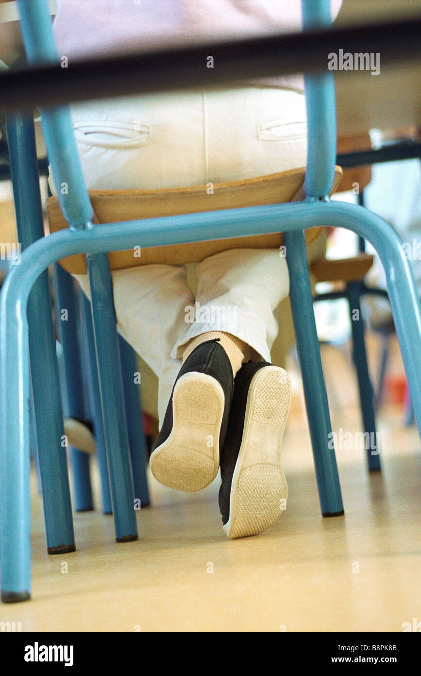 Child sitting in chair, legs crossed at ankle, low angle view Stock ...