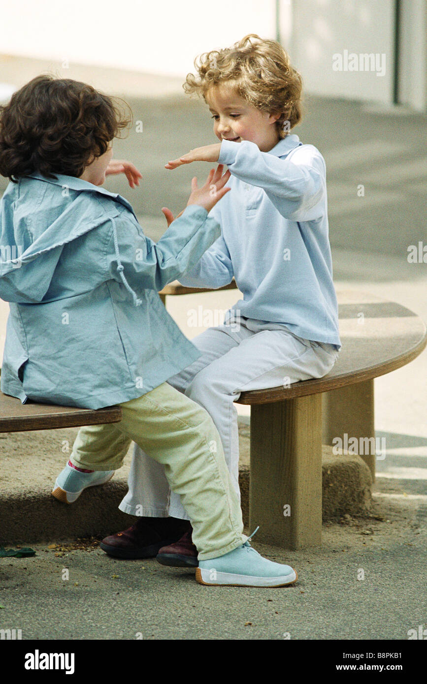Girls playing clapping game on bench Stock Photo - Alamy