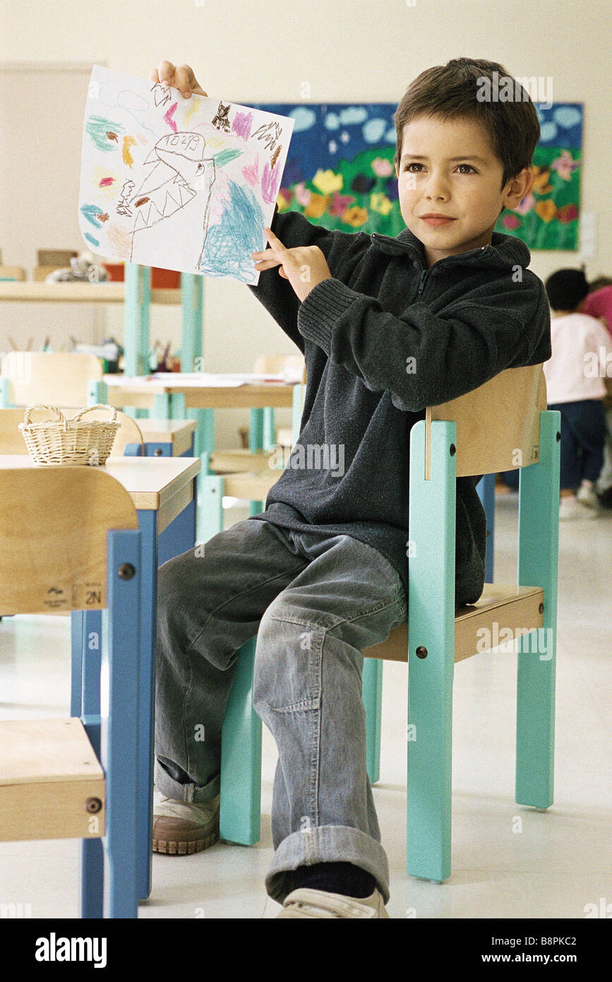 Boy showing drawing in class room Stock Photo - Alamy