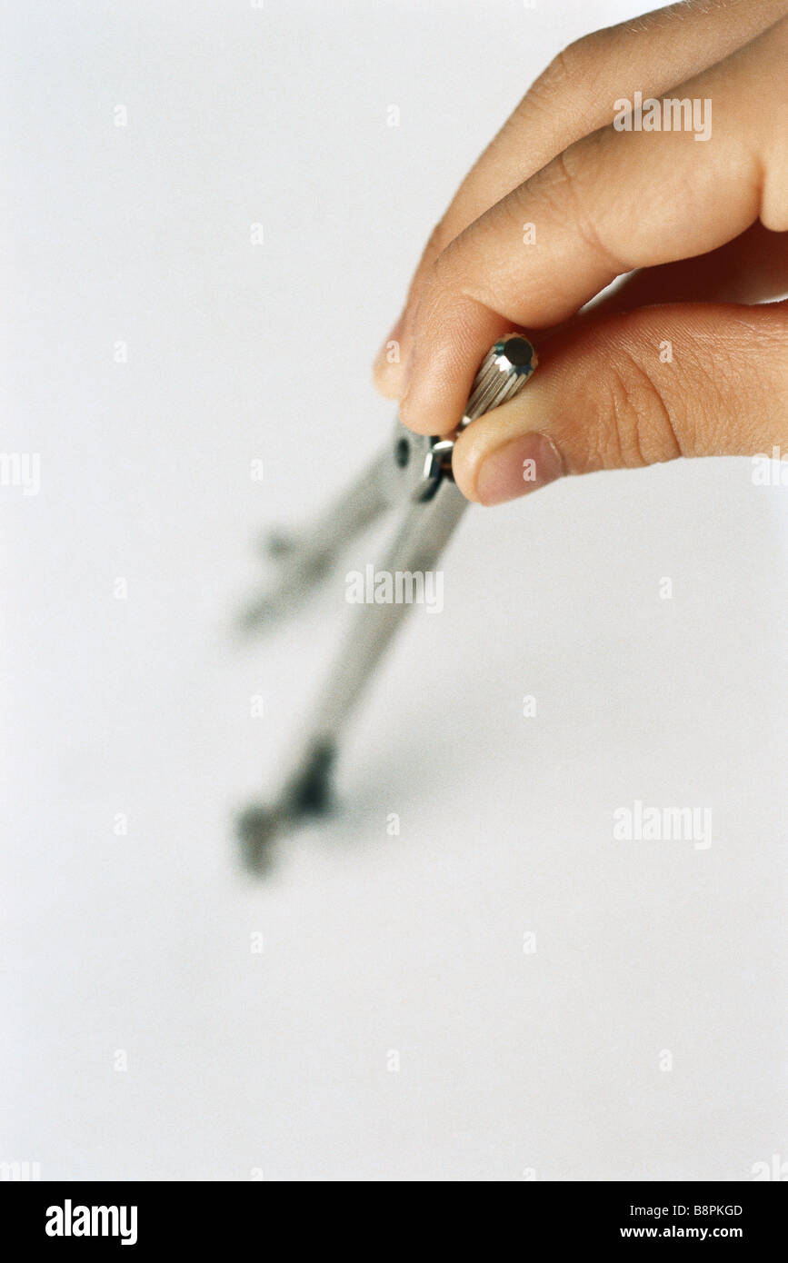 Hand holding drawing compass Stock Photo - Alamy