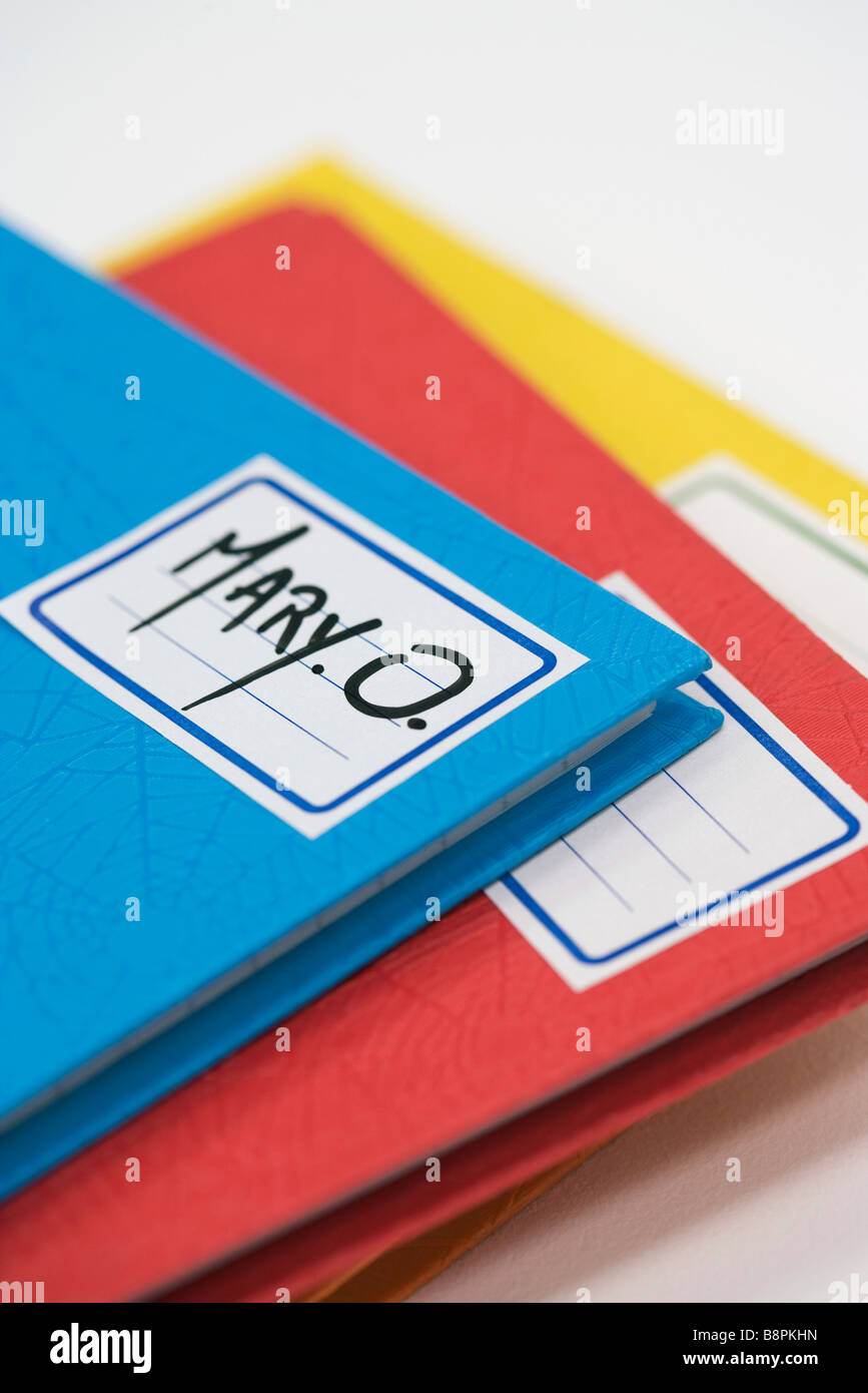 Pile of school notebooks with name written on label Stock Photo - Alamy