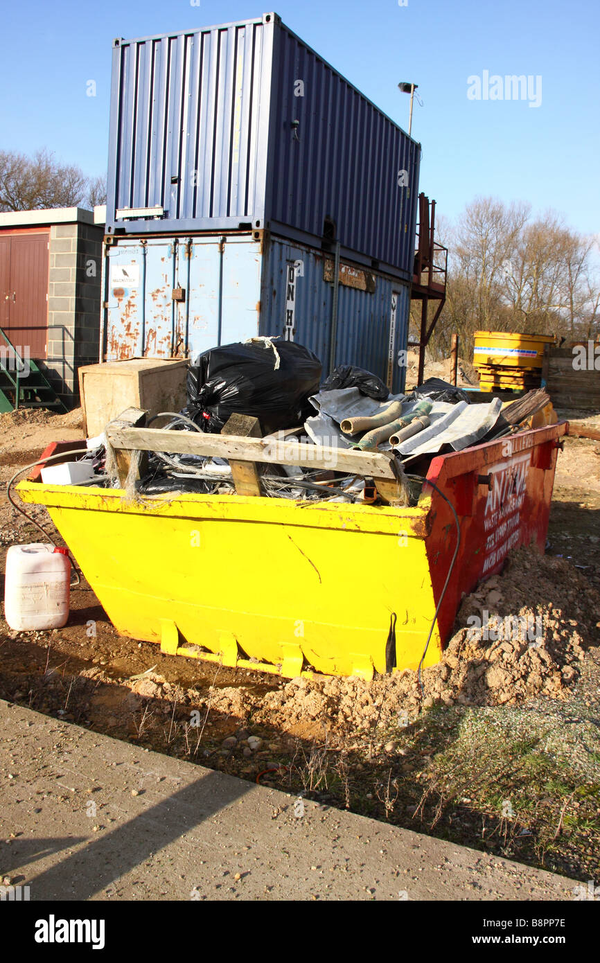 overflowing yellow skip in cromwell quarry with empty barrels spilling ...