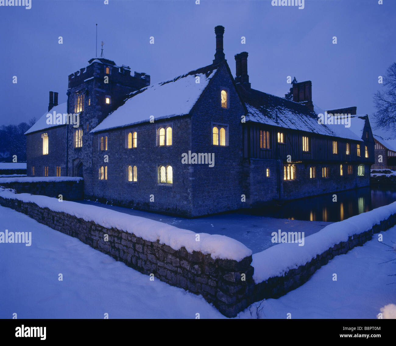 Ightham Mote under snow at twilight with brightly lit windows a view ...