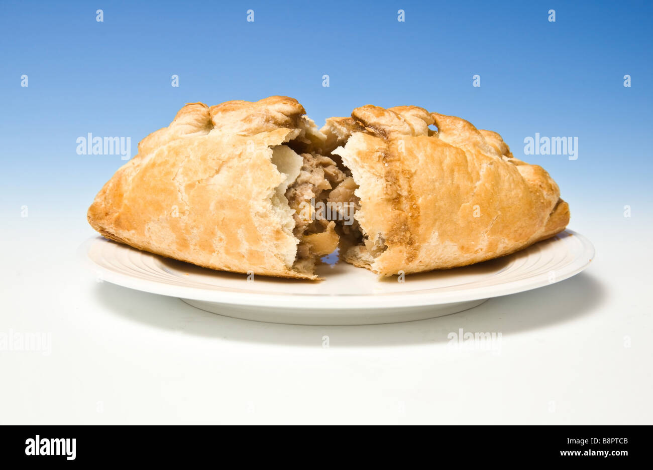 Cornish pasty on a graduated blue studio background Stock Photo - Alamy