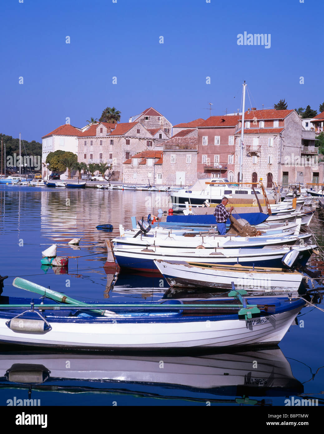 Supetar, Brac Island, Croatia. With fisherman mending his nets Stock ...