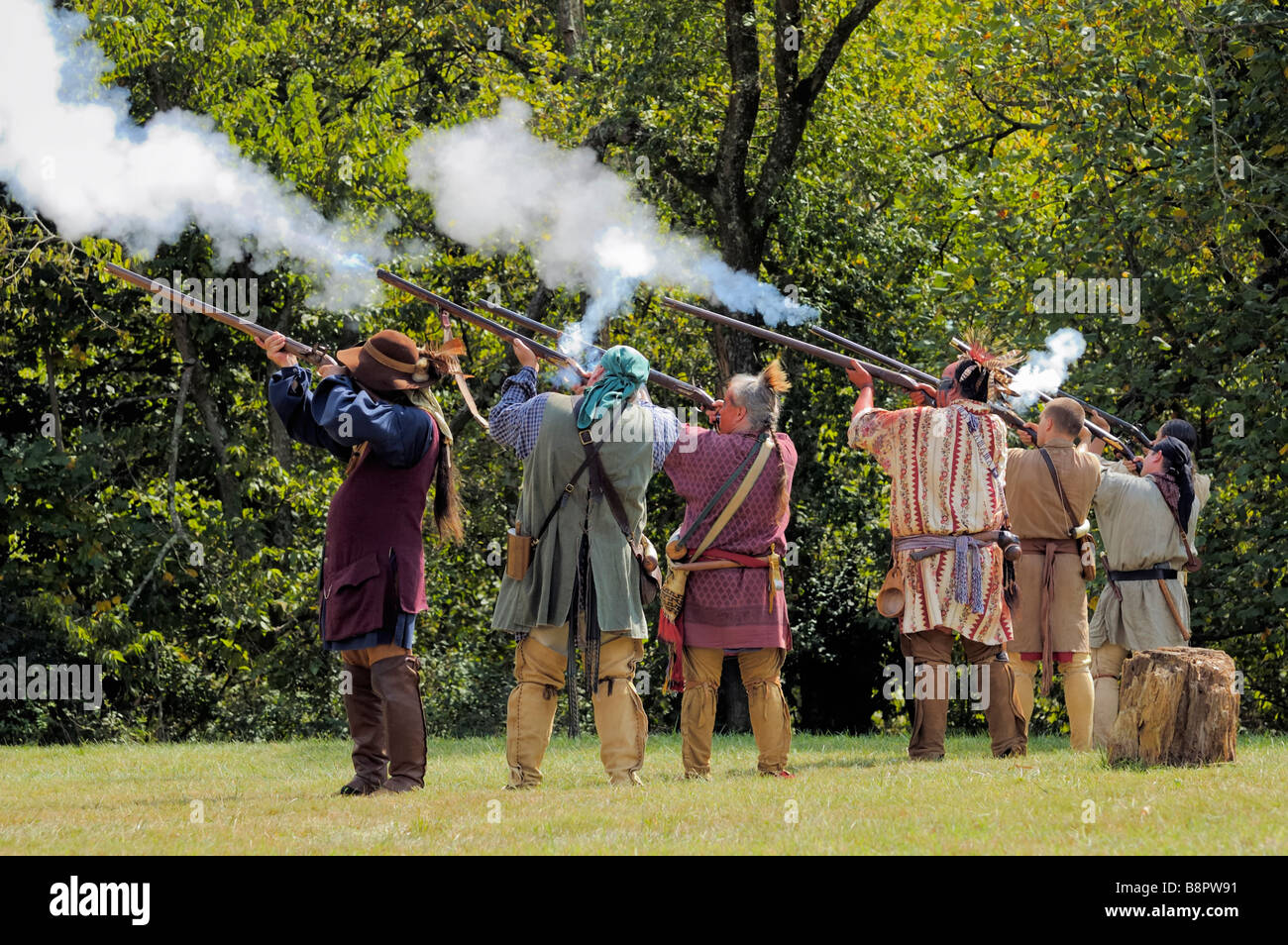 Native American Indian and pioneer reenactors firing flintlock rifles ...