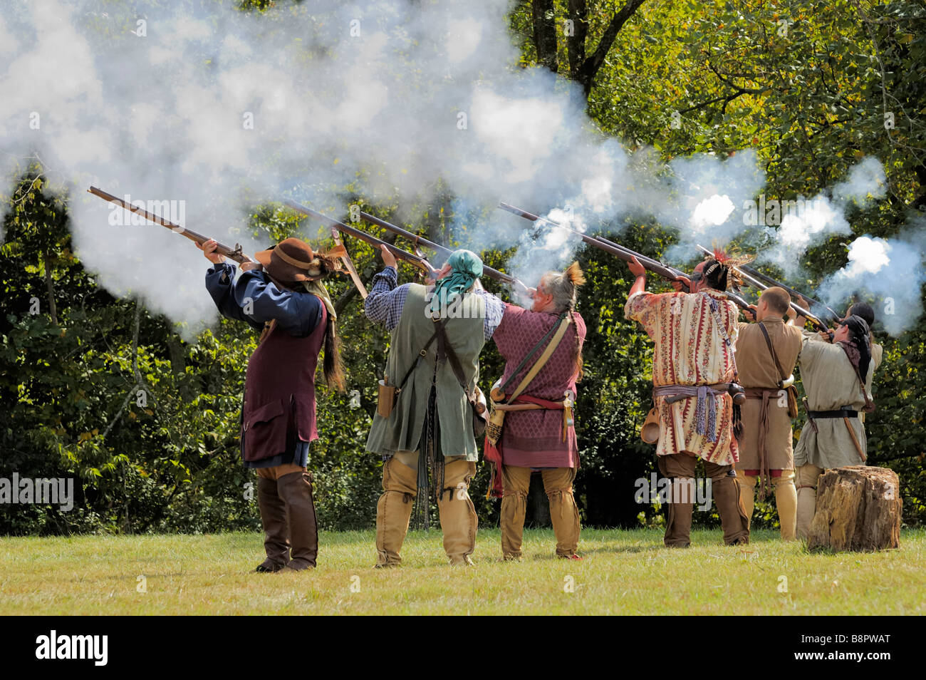 Native American Indian and pioneer reenactors firing flintlock rifles ...
