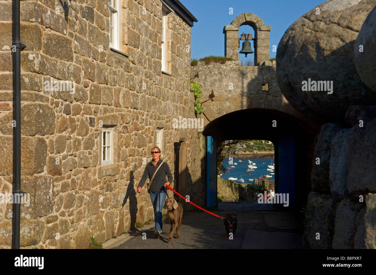 A woman is walking two dogs at the Garrison Gateway. Hugh Town. St Mary ...