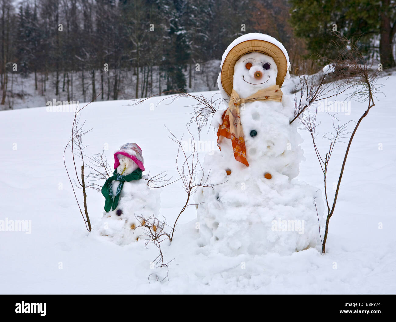 Two Snowmen wearing hats and scarves Stock Photo - Alamy