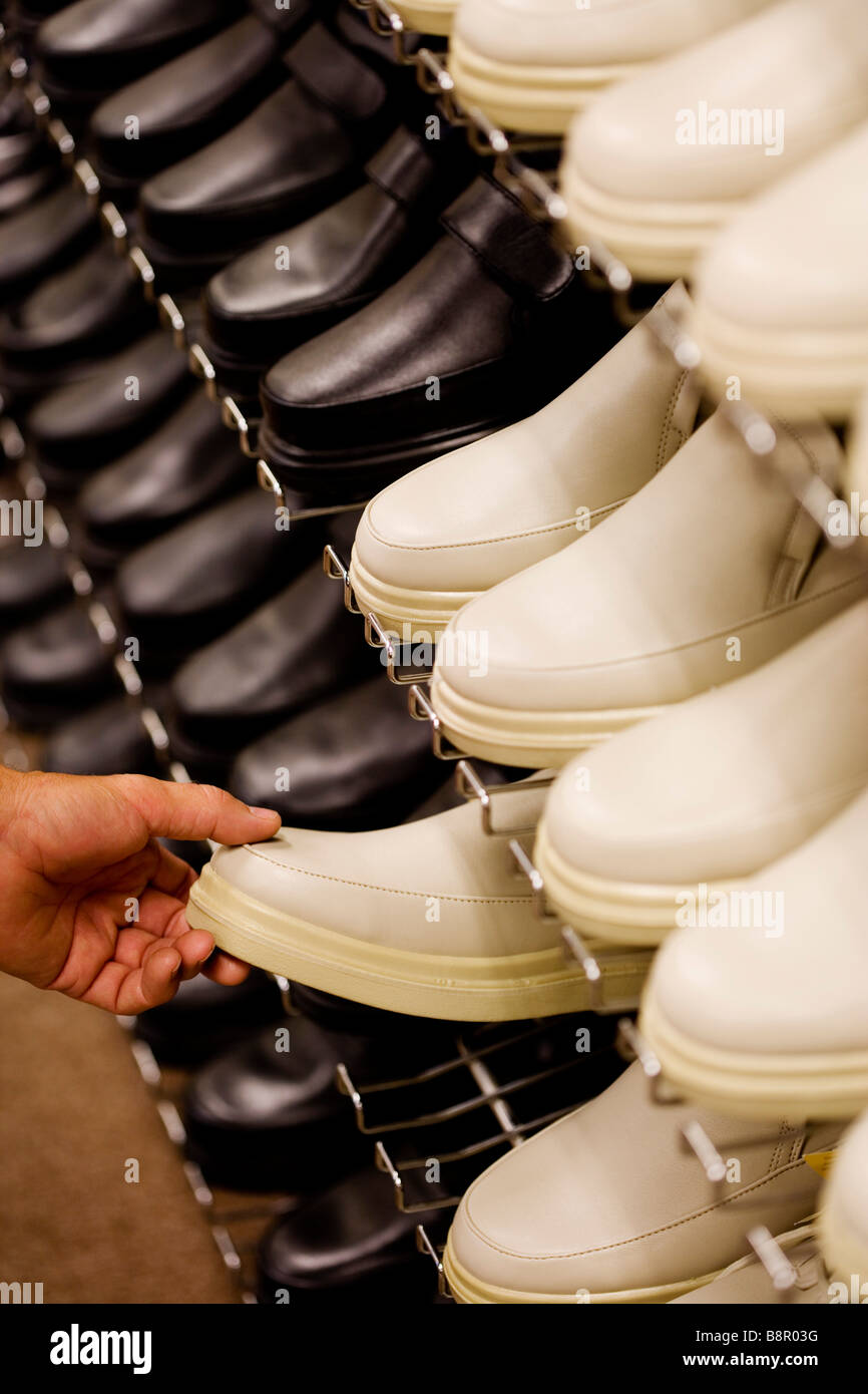 Hand picking a shoe in a shoe-store Stock Photo - Alamy