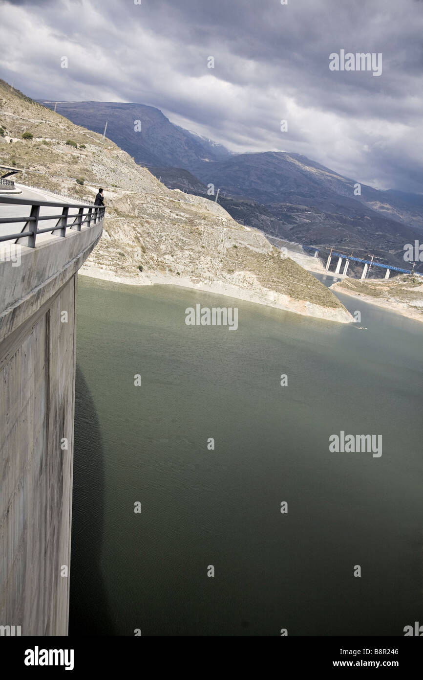 A man dressed in a suit stands on top of a dam Stock Photo - Alamy