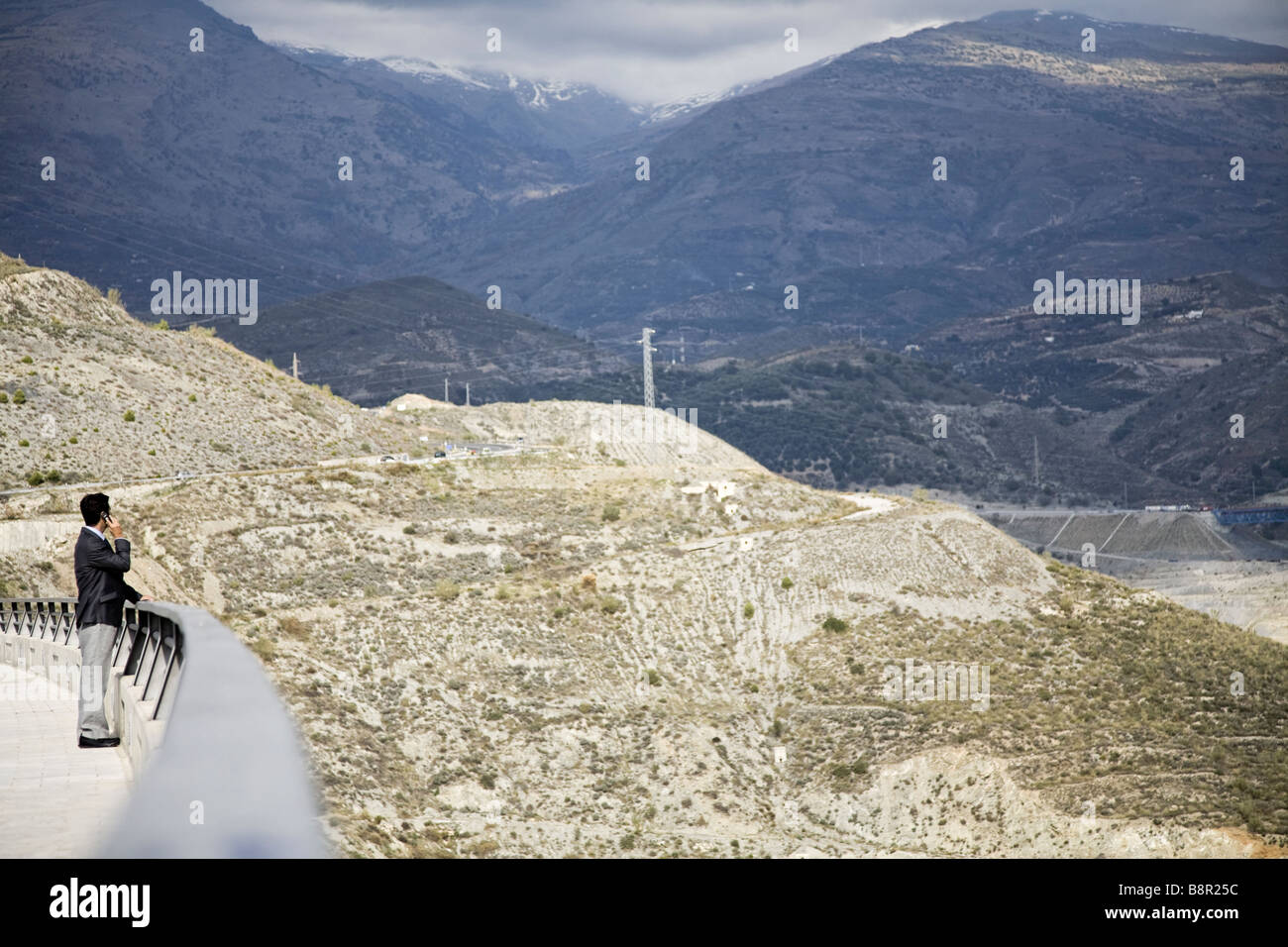 A man dressed in a suit stands on top of a dam Stock Photo - Alamy