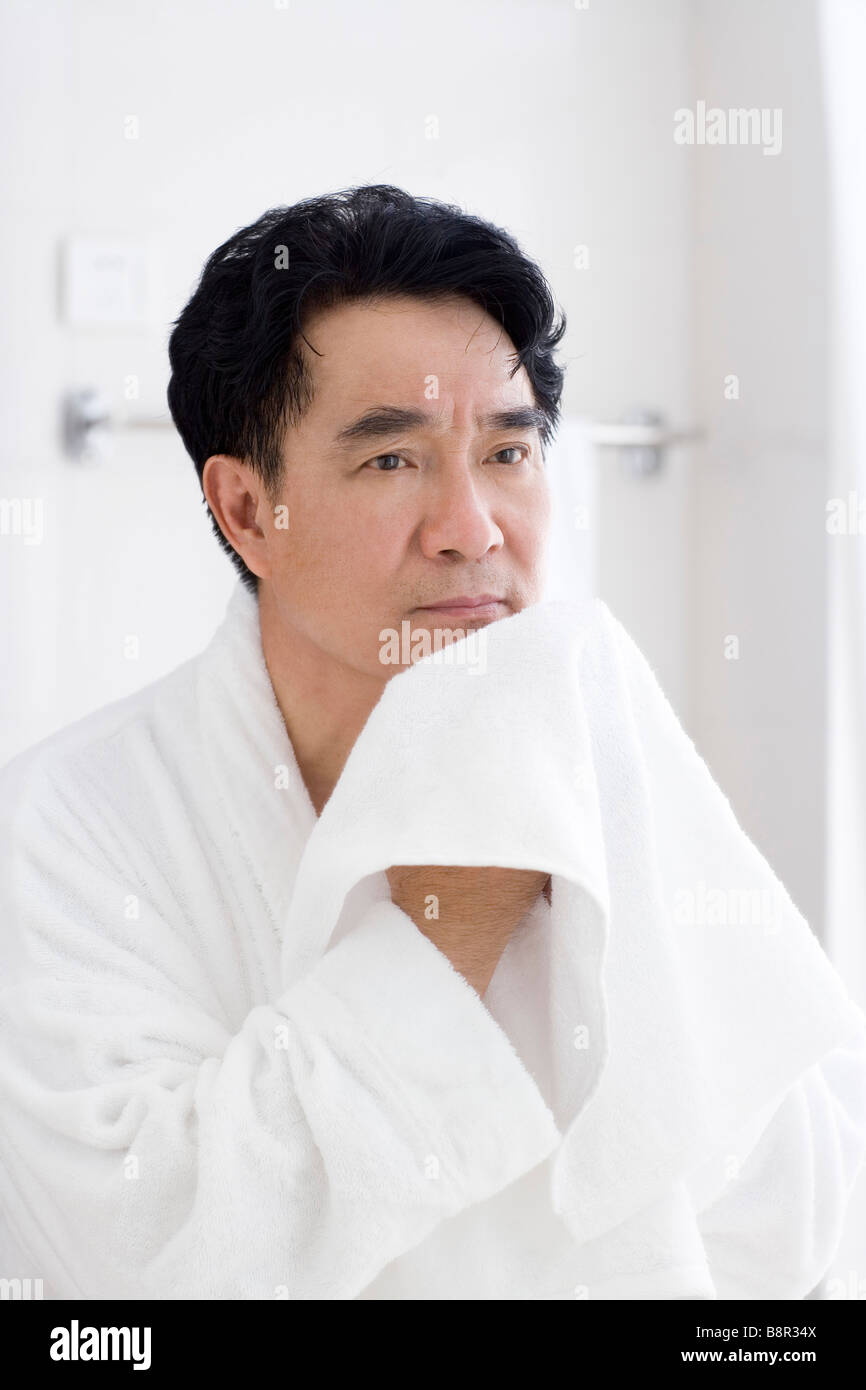 Senior man drying face with towel in bathroom Stock Photo - Alamy