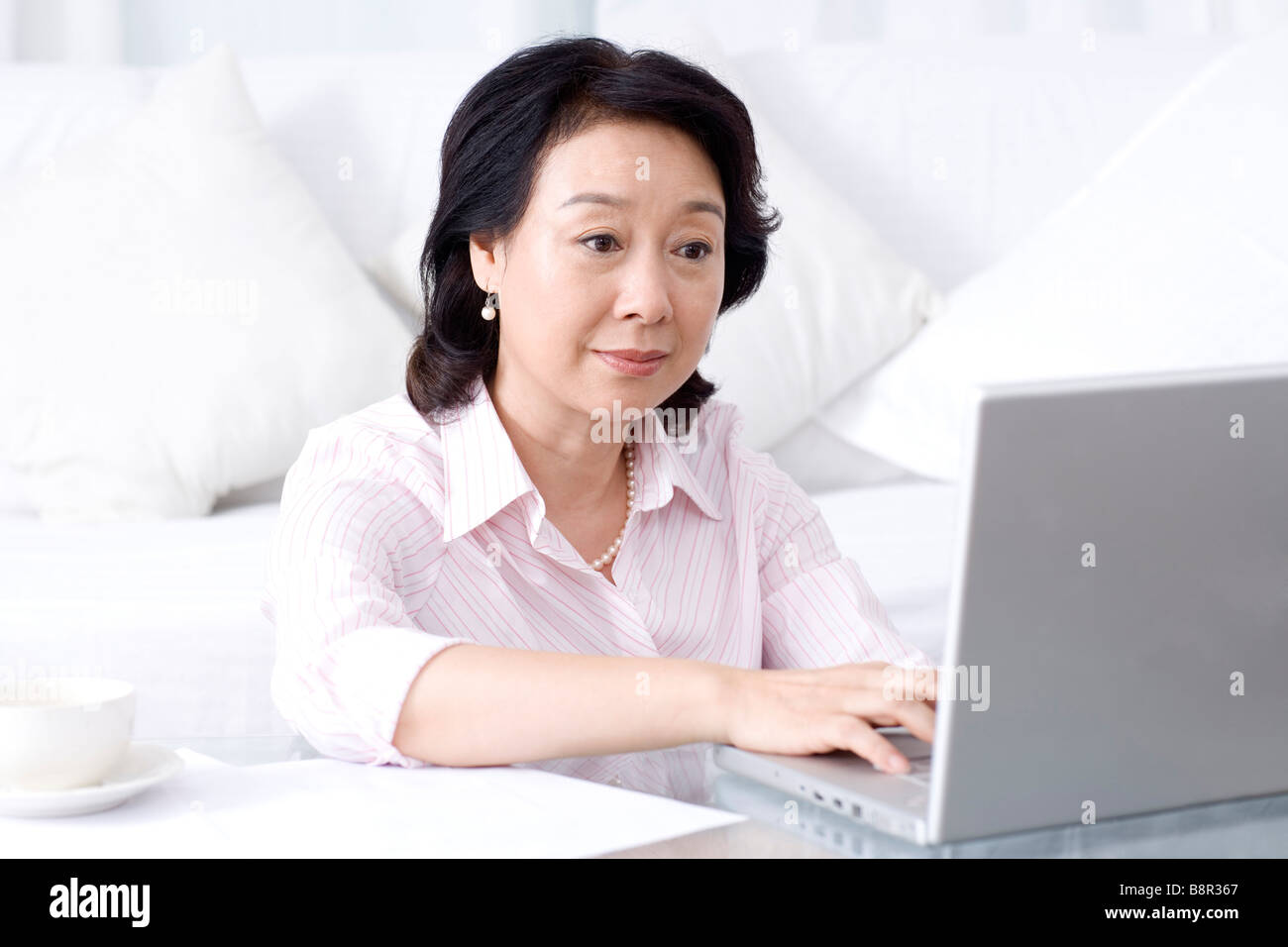 Senior woman using laptop Stock Photo - Alamy