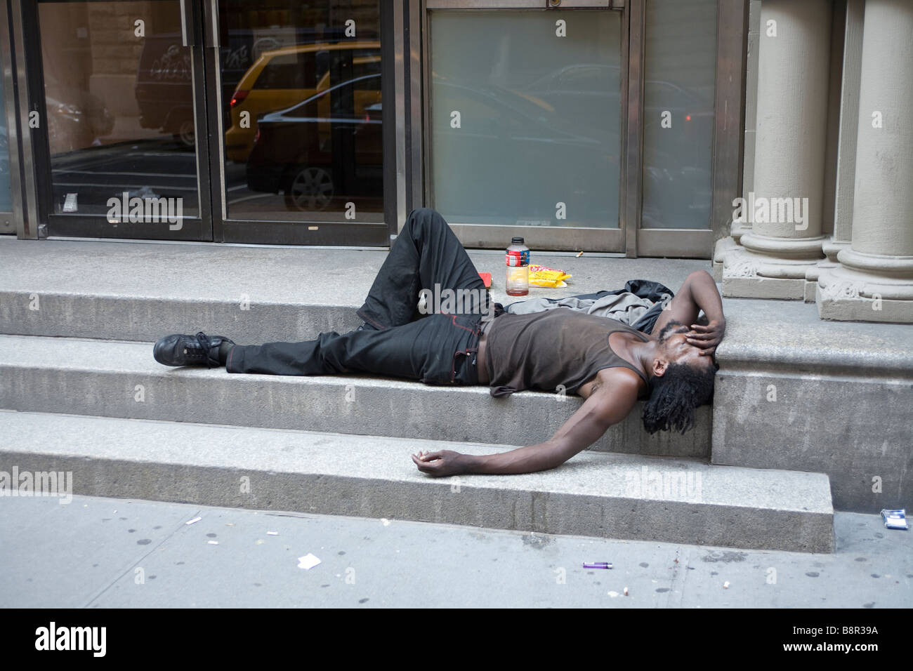 Sleeping vagrant on the street in midtown Manhattan Stock Photo - Alamy