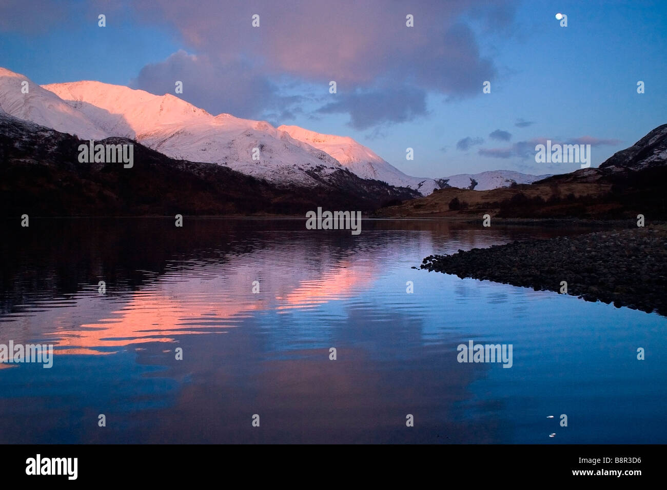 Snowy mountains lit by setting sun, near Kinlochleven, Highlands ...