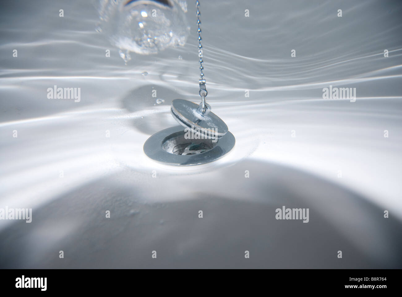 an underwater shot of a plug coming out of a plug hole and air bubbles ...