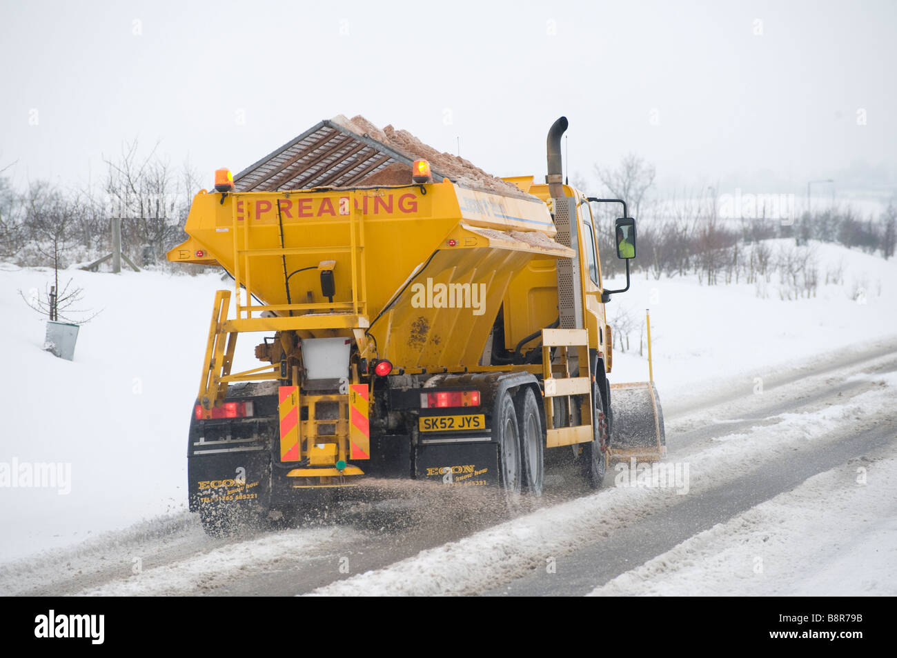 Gritter lorry with snow plough fitted to the front clearing the roads ...