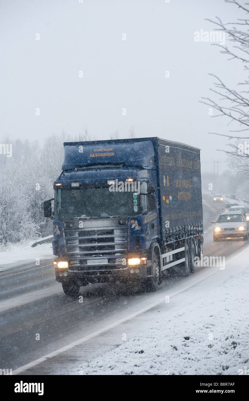 Lorry driving slowly on a snowy road in winter in England Stock Photo ...