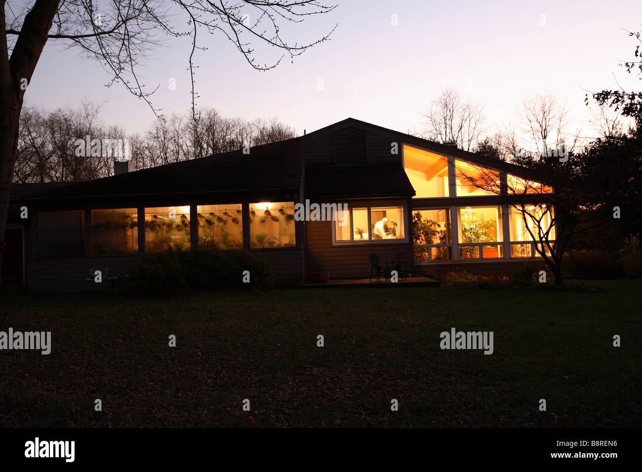 Large low contemporary ranch house at dusk with inside illumination at ...