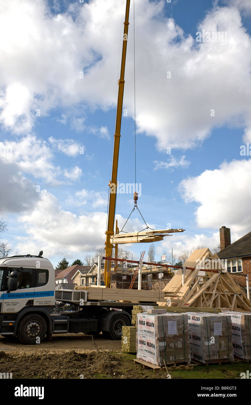 A crane being used to unload a delivery of roofing timbers made off ...