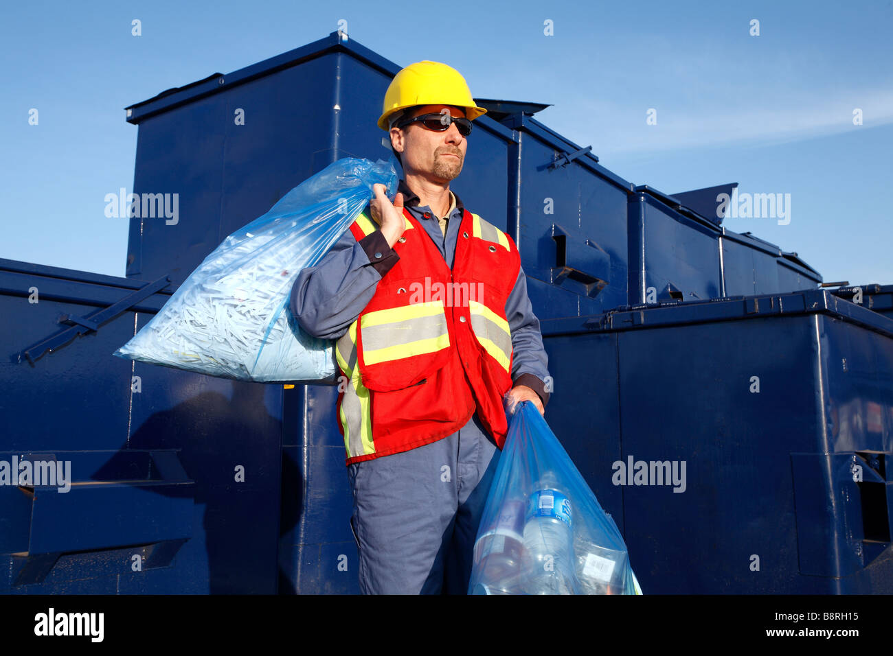 Recycle company worker holding bags of plastic and shredded paper in ...