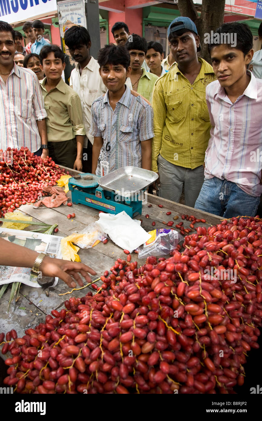 Street market seller with his fresh fruit (fresh dates from the look of ...