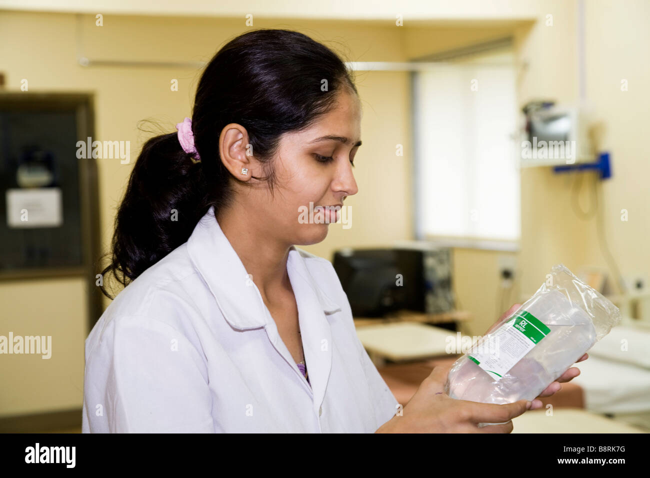 Nurse with a bag of drip solution on the ward of the Essar Hospital ...