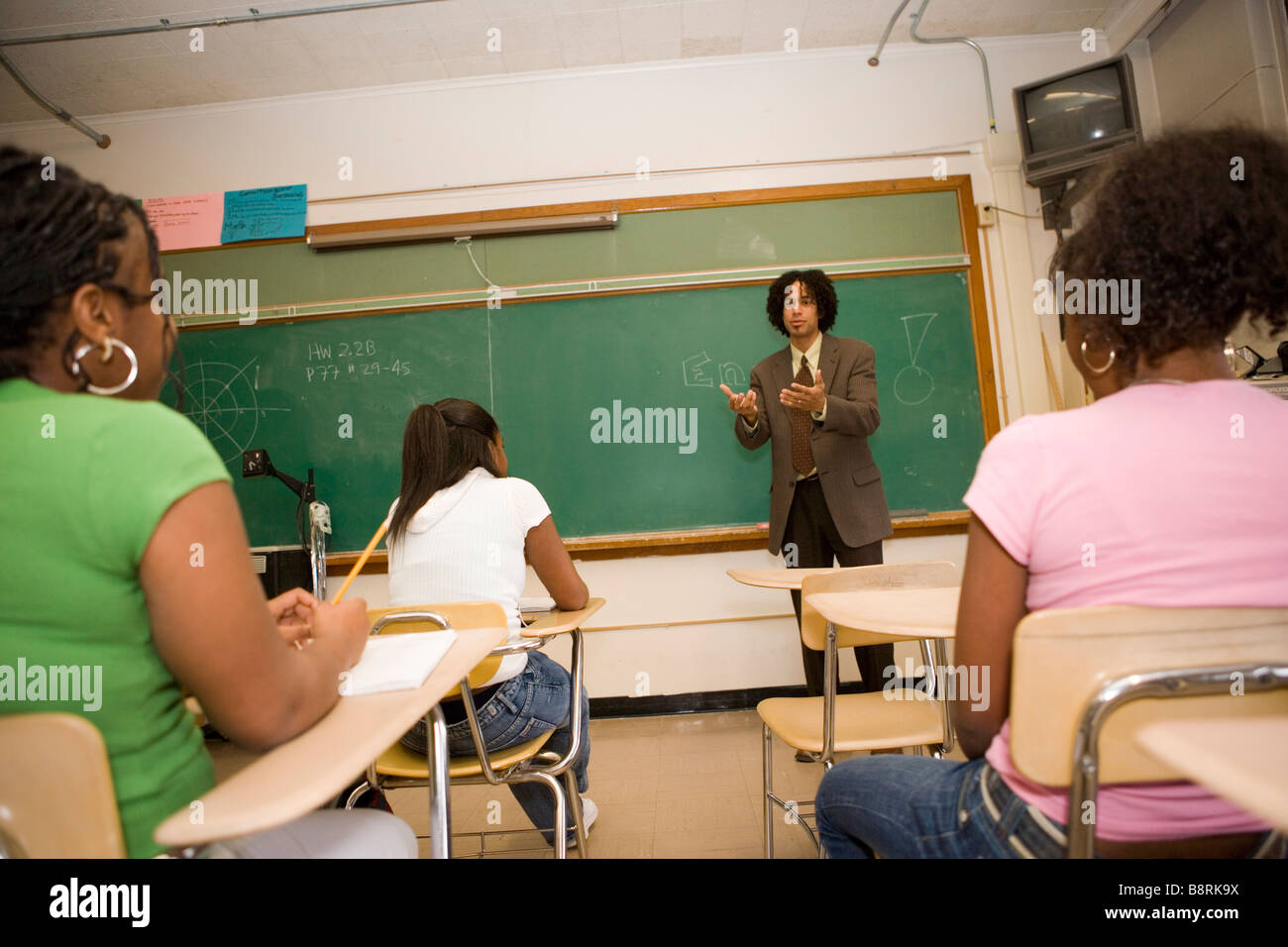 middle school teacher giving a lecture to teen students, classroom ...